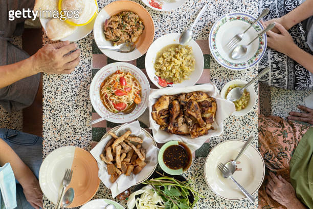 Family eating lunch, papaya salad, sticky rice, grilled chicken, fried ...