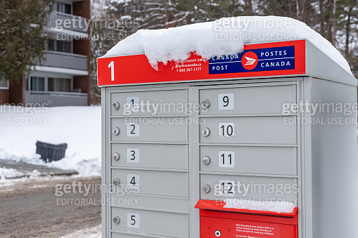 Canada Post mailboxes with red sign in English and French near house in ...