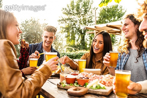 Happy mixed race family having dinner together outdoor - Young people ...