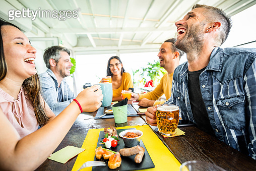 Young people laughing together having brunch meal - Happy multiracial ...