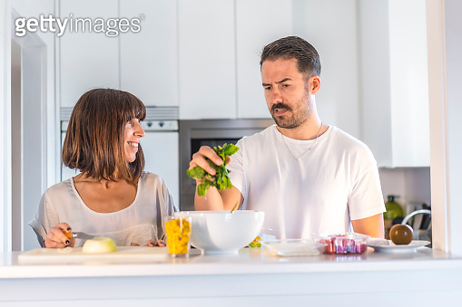 A Caucasian couple cooking together at home, cooking in confinement ...