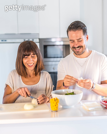 A Caucasian couple cooking together at home, cooking in confinement ...