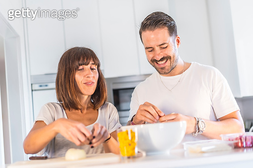 A Caucasian couple cooking together at home, cooking in confinement ...