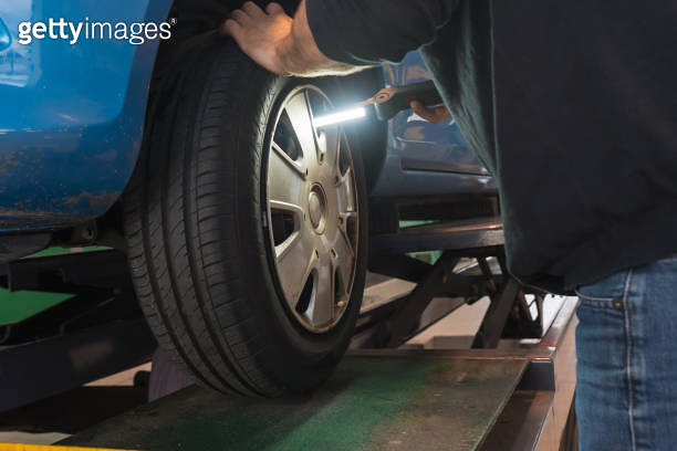 Workshop car inspection, checking with a flashlight the malformations ...