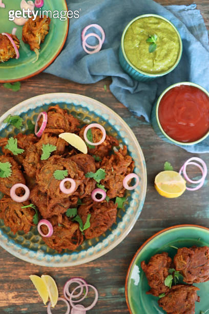 Image of pile of homemade crispy onion bhajis / pakoras garnished with ...