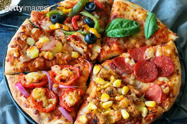 Close-up image sliced pizzas various toppings including chicken and ...