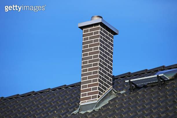 Chimney clad with clinker bricks on a newly covered roof (1300446572 ...