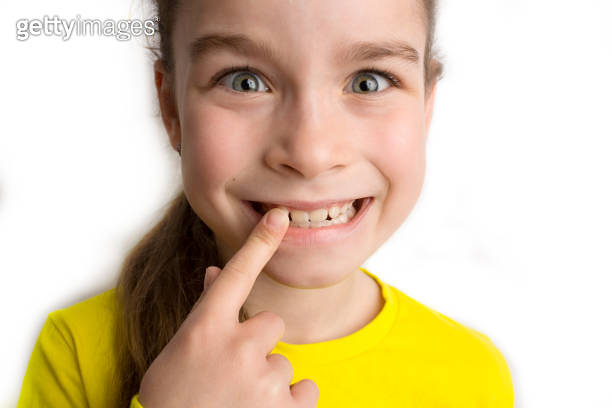 Little girl stands on a white background with a beautiful smile ...