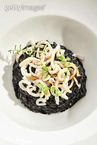 Risotto with cuttlefish black ink. Black risotto plate isolated on ...