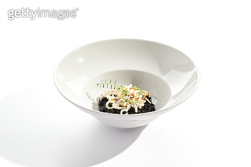 Risotto with cuttlefish black ink. Black risotto plate isolated on ...