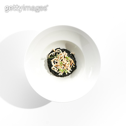 Risotto with cuttlefish black ink. Black risotto plate isolated on ...