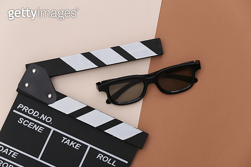 Movie clapper board and 3d glasses on beige brown background ...