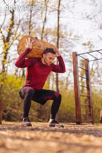 Man doing squats while lifting a tree log outdoors 이미지 (1330697306 ...
