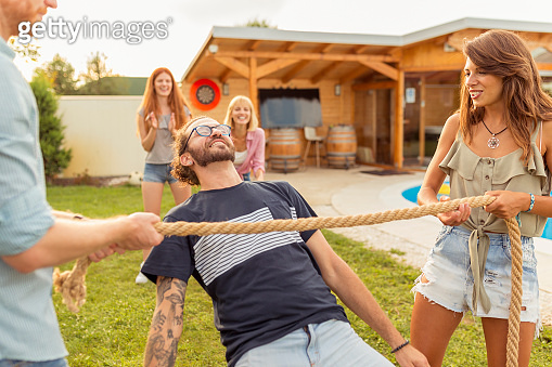 Man passing below the rope while participating in limbo dance contest ...