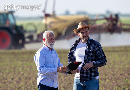 Farmer and insurance agent talking in agricultural field in spring 이미지 ...