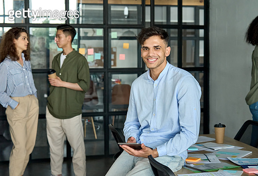 Young happy male Indian Hispanic leader manager with team, portrait ...