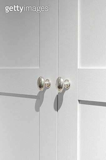 Furniture fittings. Metallic silver door handles with sharp shadows on ...