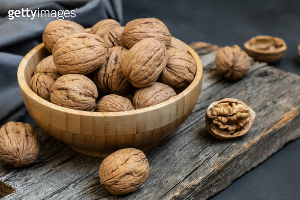 Ripe and raw whole big walnut kernel with shell on rustic backdrop ...