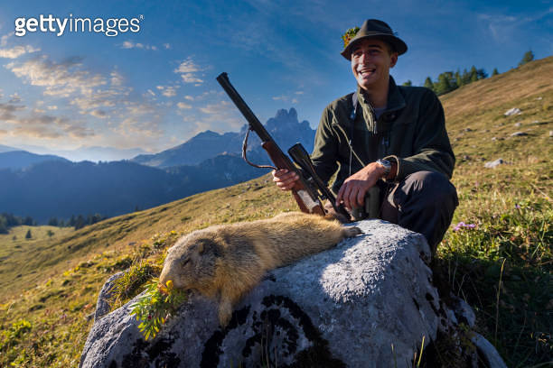 Hunters in the Alps in front of the hunted Marmot (1342605515) - 게티이미지뱅크
