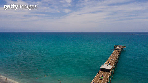 Aerial View of the Pier in Juno Beach, Florida with Bright Blue Ocean ...
