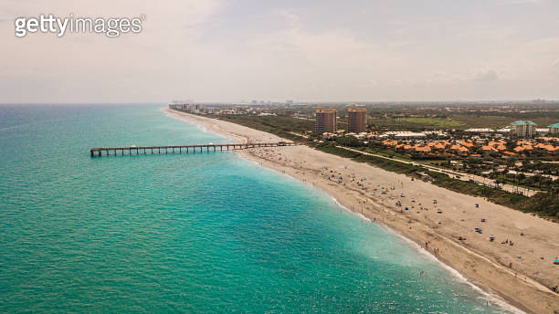 Aerial View of the Pier in Juno Beach, Florida with Bright Blue Ocean ...