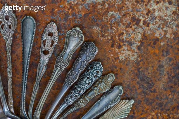 Beautiful different handles of vintage spoons on a rusty background ...
