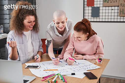 Girls drawing together while preparing to the rally about women's ...