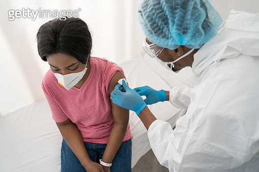 Doctor cleaning skin on female patient's arm with disinfectant before ...