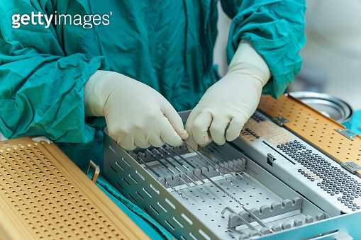 Assistant Orthopedic doctor preparing instruments for operation bone ...