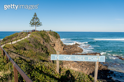 Ocean waves with white foam and One Tree Point lookout at Tuross Head ...