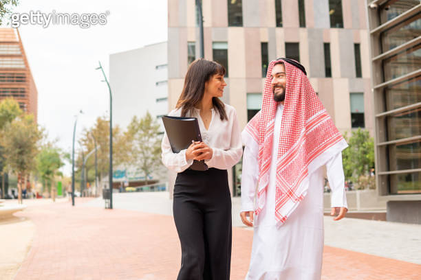 Two multiracial business partners arab man and european woman talking ...