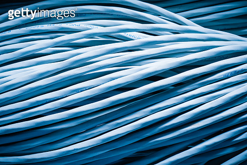bunch of network cables in wave pattern leading across server ro ...