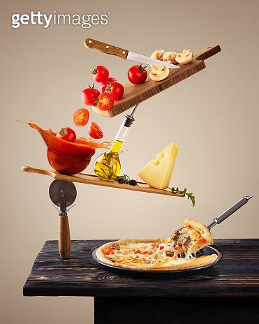 Balancing ingredients for making pizza. Levitation tomatoes. Conceptual ...