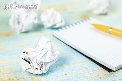 Writing concept - crumpled up paper wads with a sheet of white paper ...