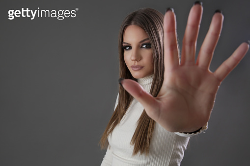 Close up portrait of a young fashionable woman showing stop gesture ...