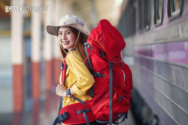 Portrait of young female backpacker smiling when arriving at her ...