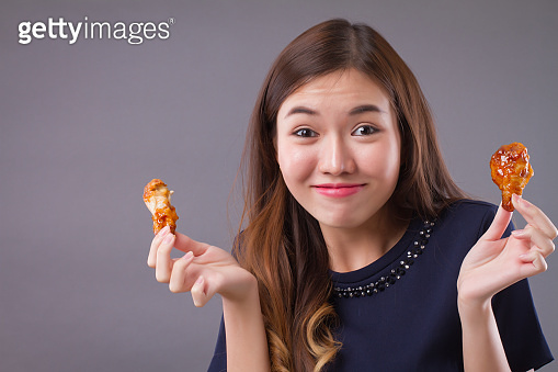 asian woman eating fried chicken; portrait of beautiful woman, happy ...