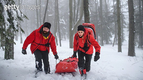 Mountain rescue service provide operation outdoors in winter in forest ...