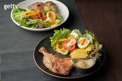 plate of delicious grilled chicken legs steak with vegetable salad on ...