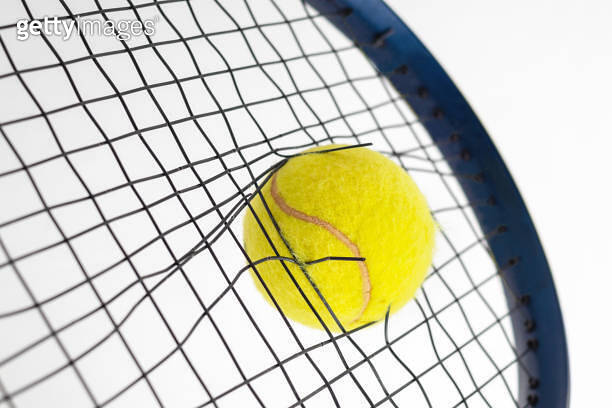 Close-up of a tennis racket with a ball stuck in broken strings, on ...