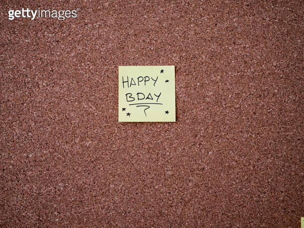 Adhesive note with happy birthday text on a bulletin board (1298557777 ...