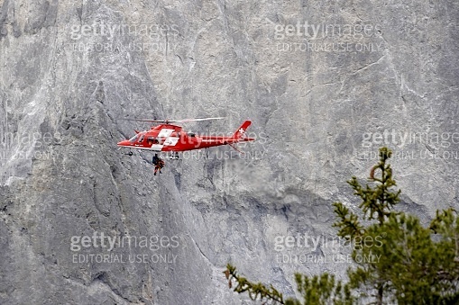 Helicopter of Swiss rescue system flying over Ruinaulta ravine or gorge, performing a rescue ...