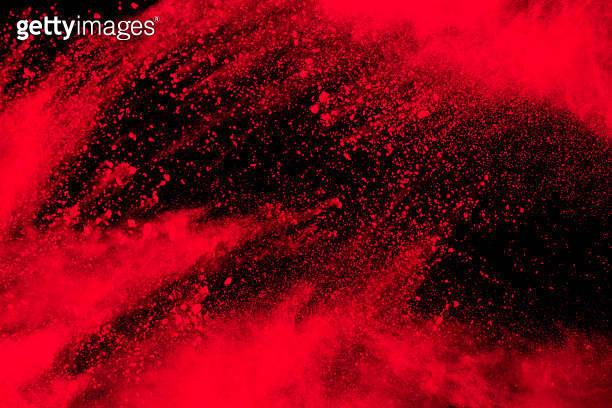 Red particle explosion on black background.Freeze motion of red dust ...