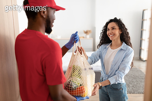 Black delivery man giving net mesh bag with groceries 이미지 (1319039410 ...