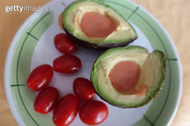 Avocado cut in half served with a mayonnaise sauce with ketchup and ...