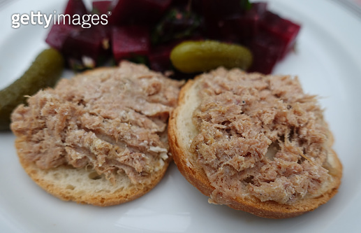 Duck rillettes in a pot and on slices of bread and red beets in ...