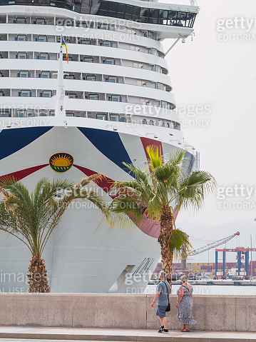 Tourist couple looking at the MS Iona cruise ship - MS Iona is an ...