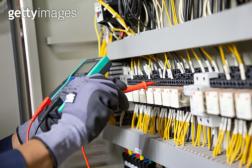 Electrician engineer tests electrical installations and wires on relay ...