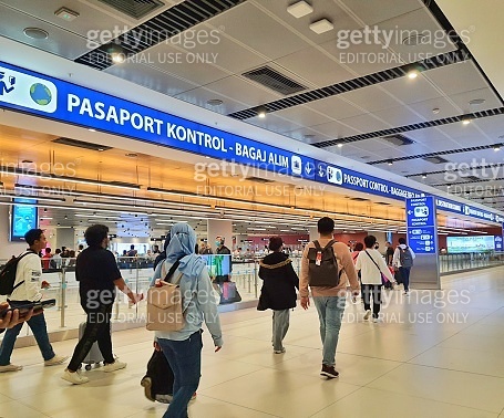 Several tourists are queuing for passport checking at the passport ...