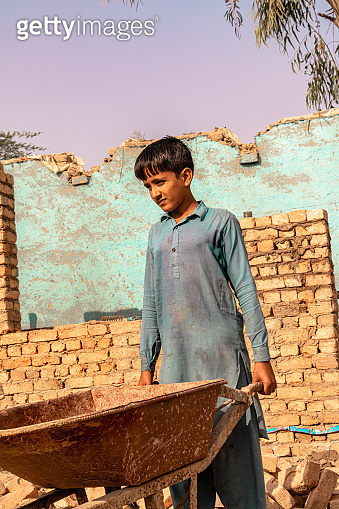 a young boy working as a labor on a construction site 이미지 (1388726496 ...